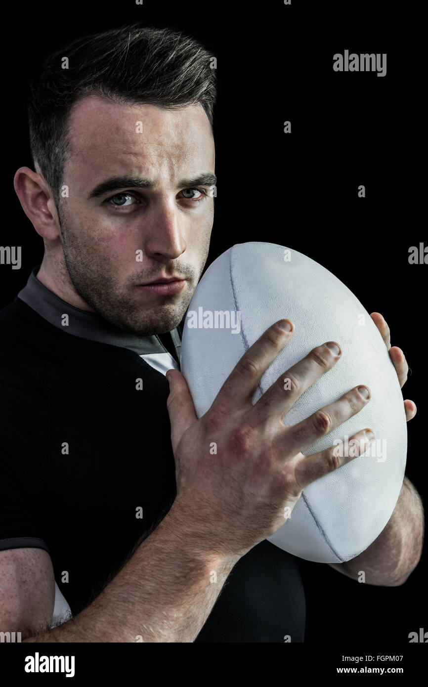 Tough rugby player holding ball Stock Photo - Alamy