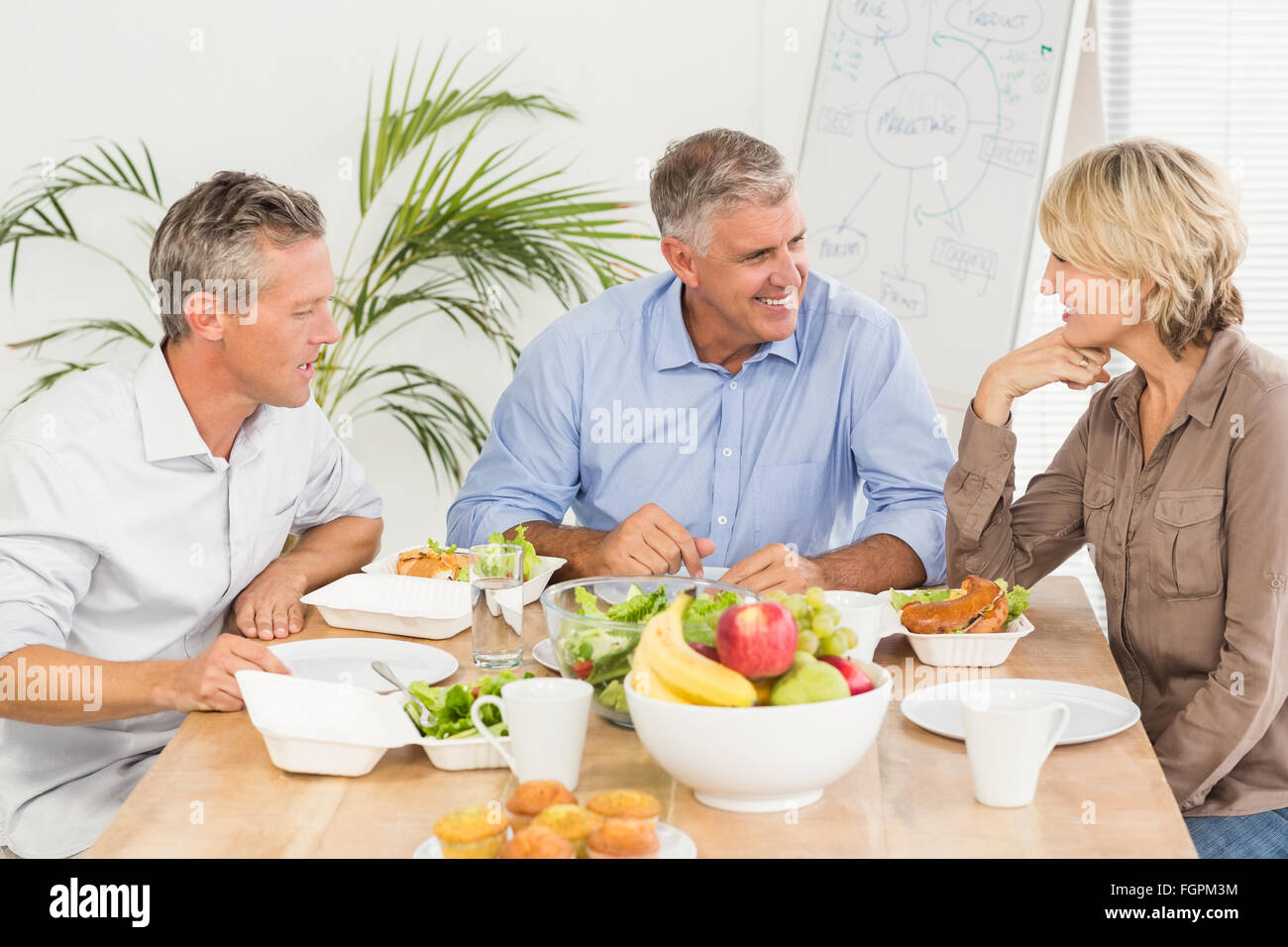 Smiling business colleagues having lunch together Stock Photo - Alamy