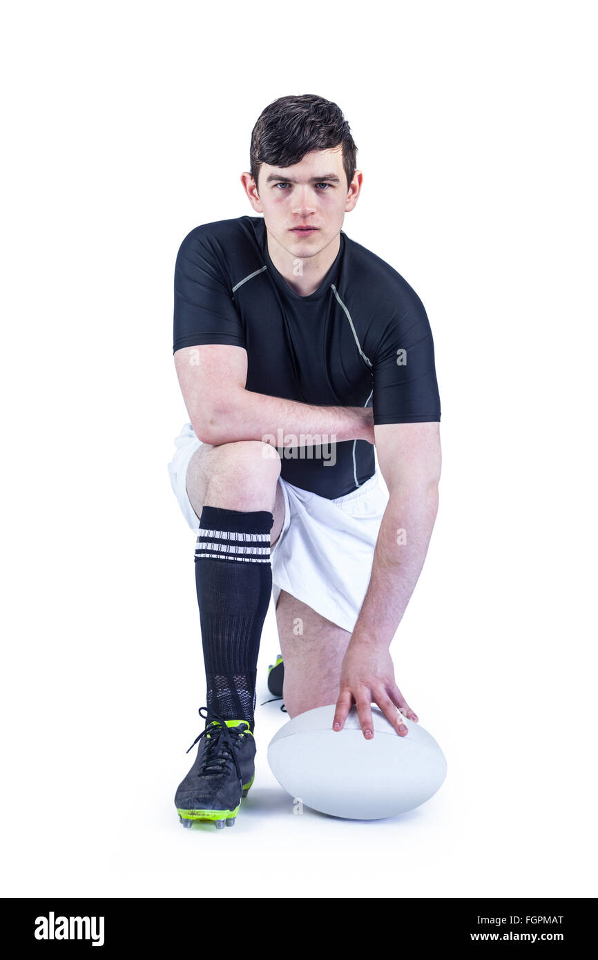 Kneeling rugby player holding a rugby ball Stock Photo - Alamy