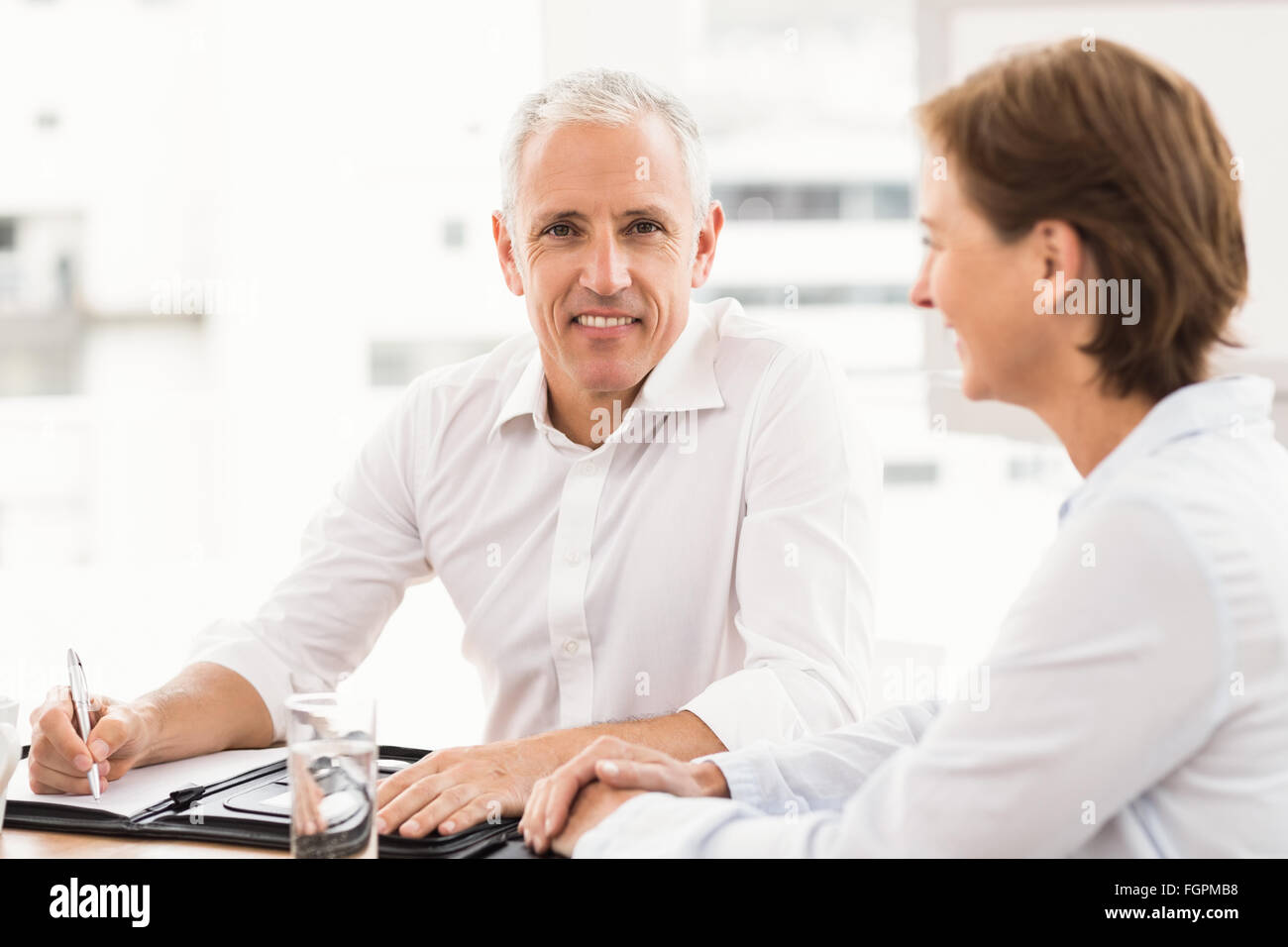 Smiling businessman making an arrangement Stock Photo - Alamy