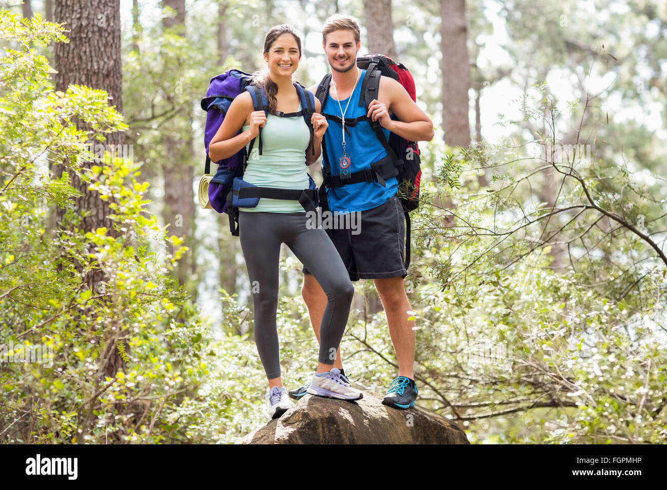 Happy hikers climbing on rock and smiling at camera Stock Photo - Alamy