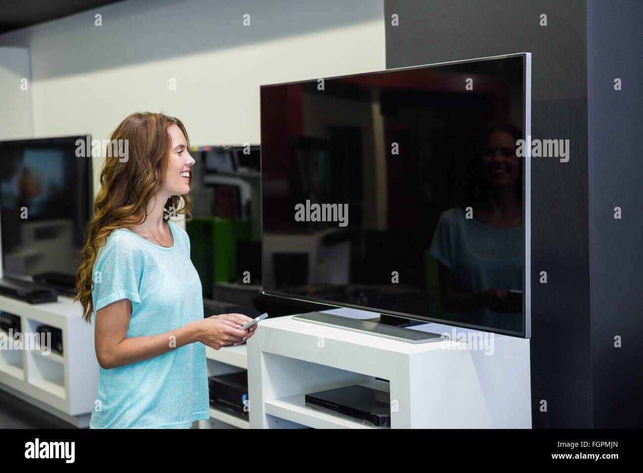 Pretty woman shopping for new television Stock Photo - Alamy