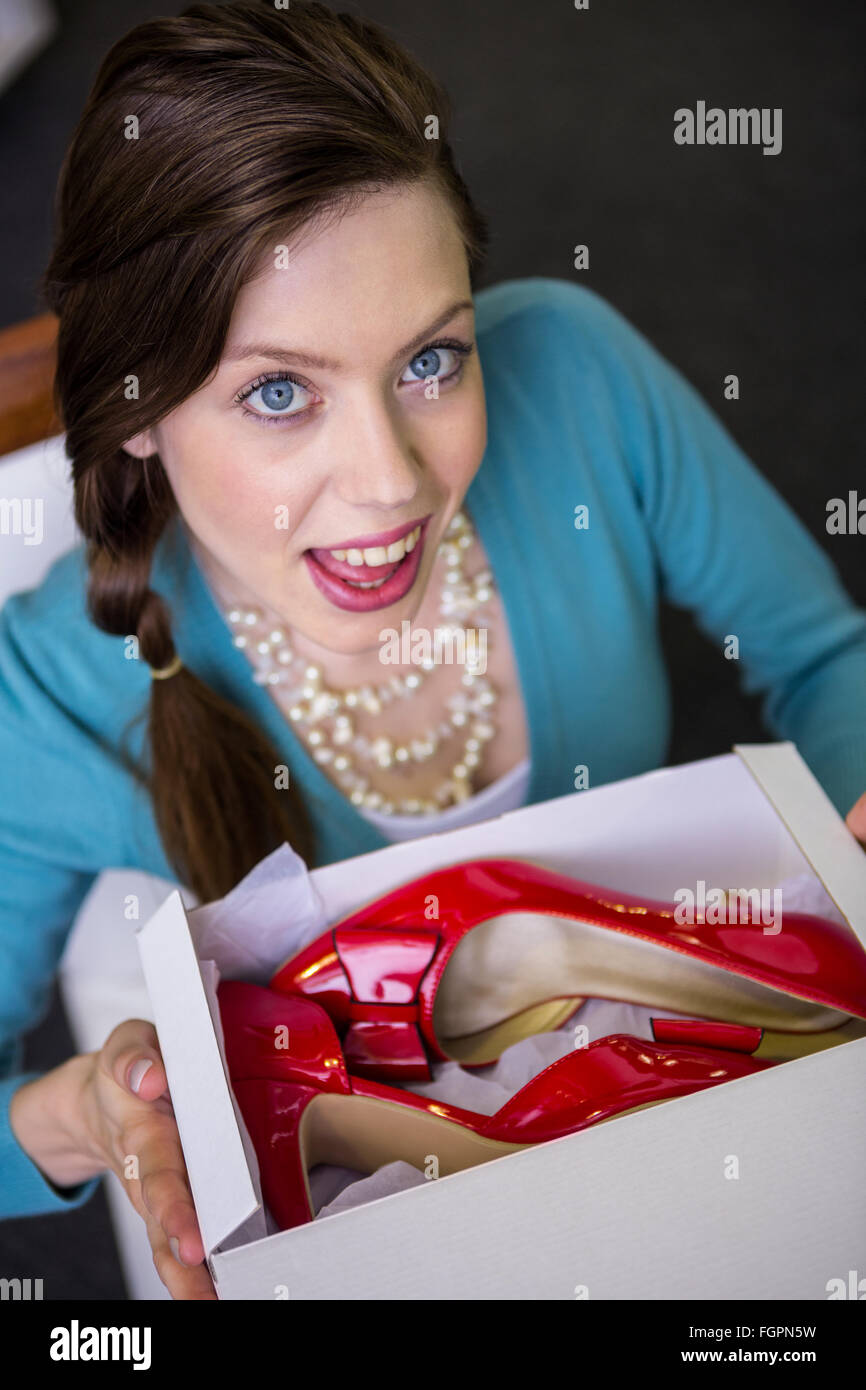 Woman showing box with red shoes Stock Photo - Alamy