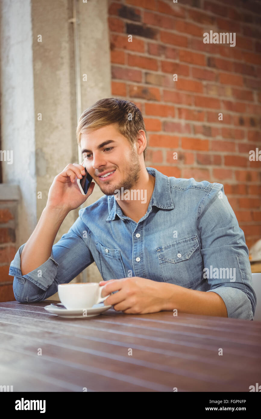 Handsome man having coffee and phoning Stock Photo - Alamy