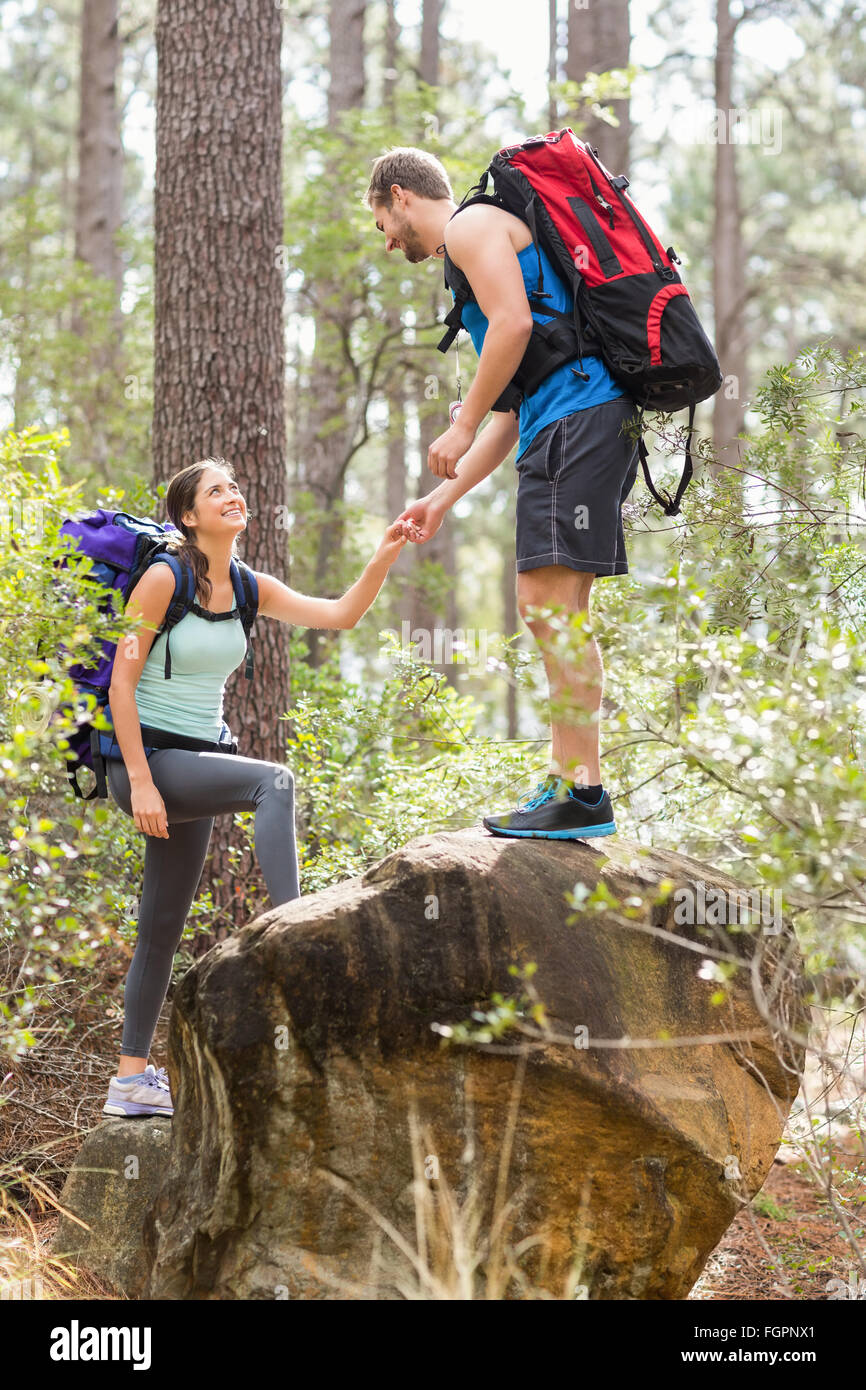 Happy hikers climbing on rock Stock Photo - Alamy