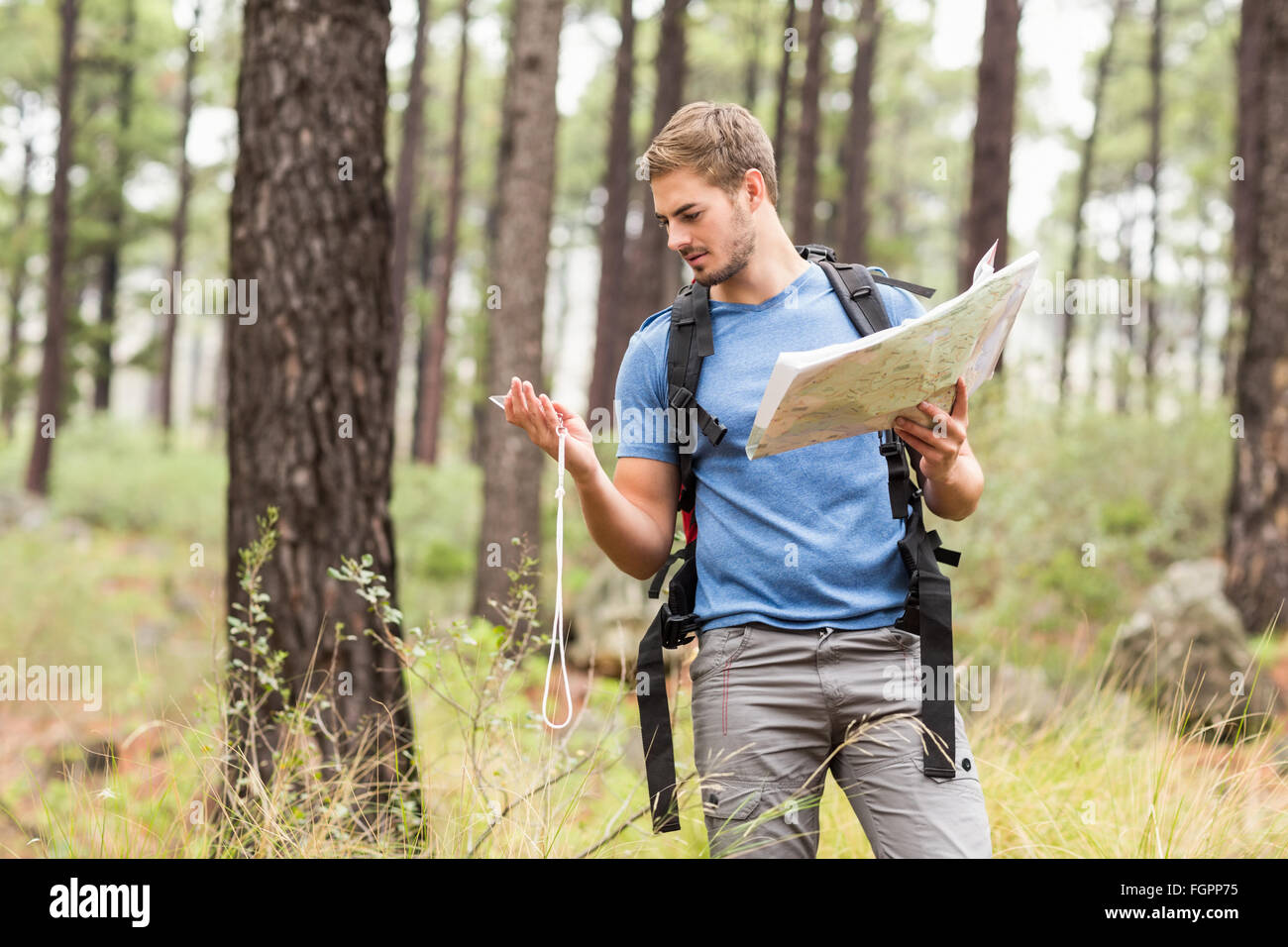 Young handsome hiker using map and compass Stock Photo - Alamy
