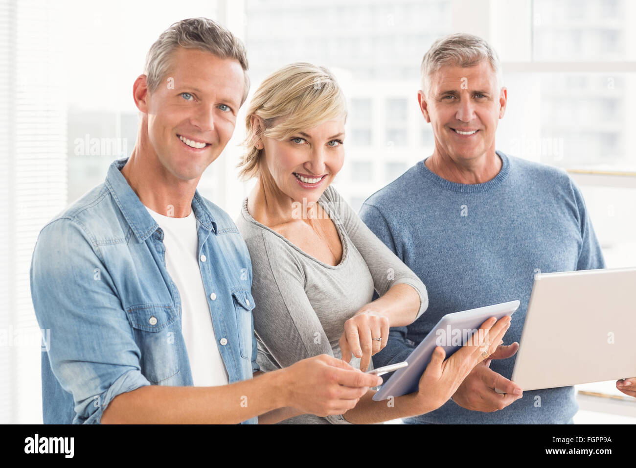 Smiling business colleagues using electronic devices Stock Photo - Alamy Smiling business colleagues using electronic devices Stock Photo - Alamy