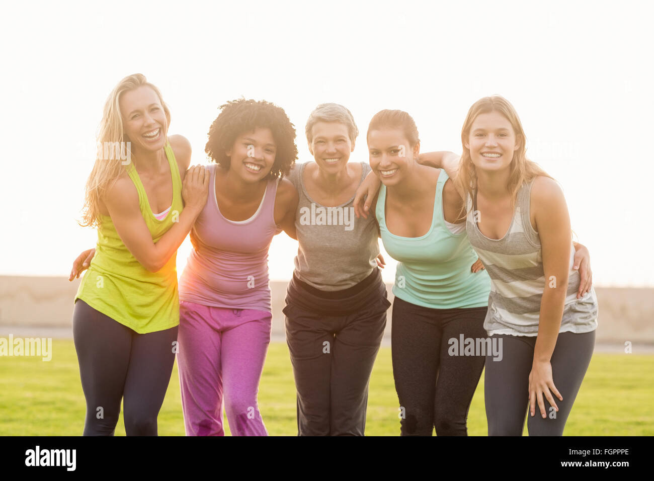 Smiling sporty women with arms around each other Stock Photo - Alamy