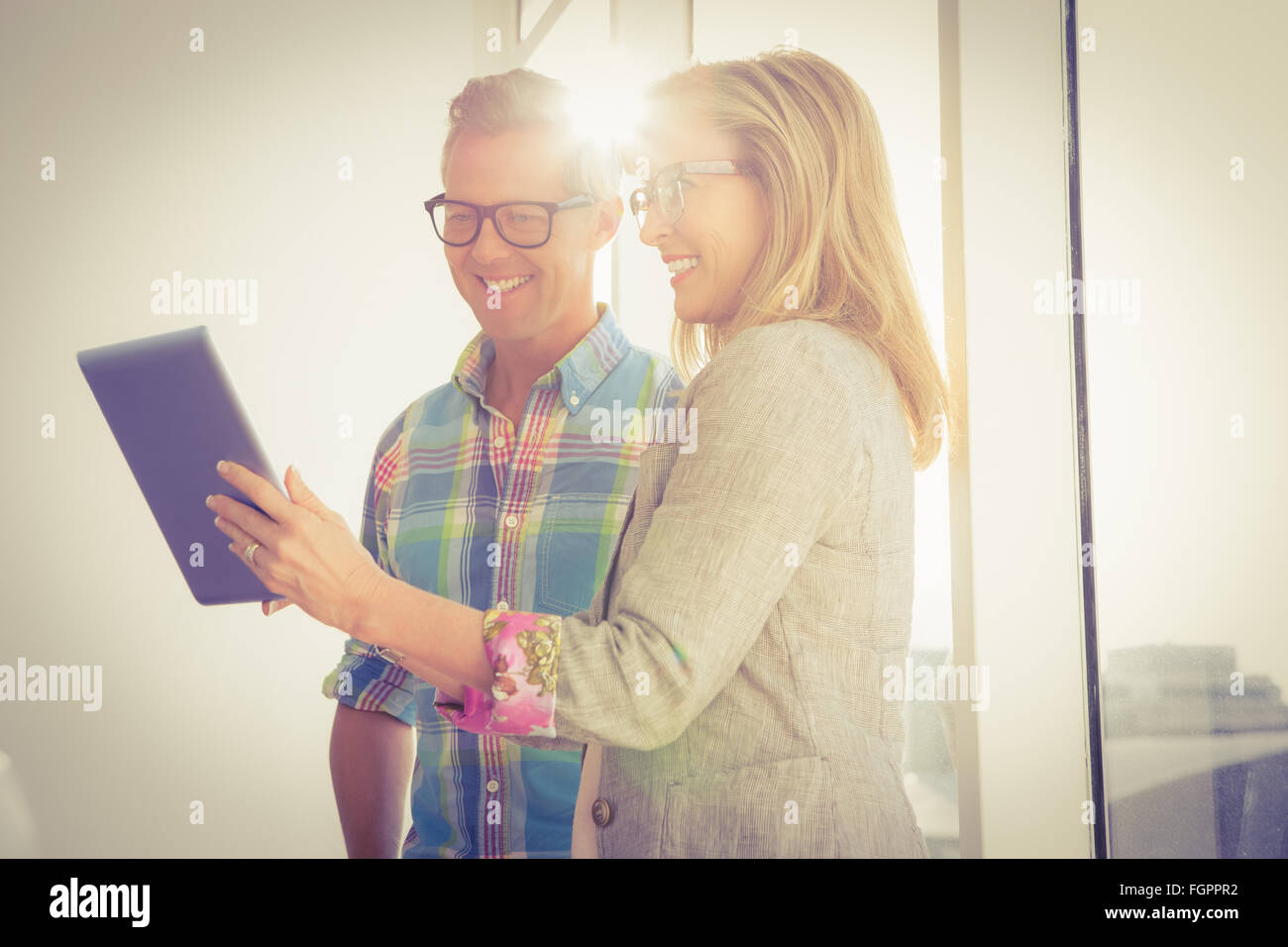 Smiling creative design team using tablet Stock Photo - Alamy