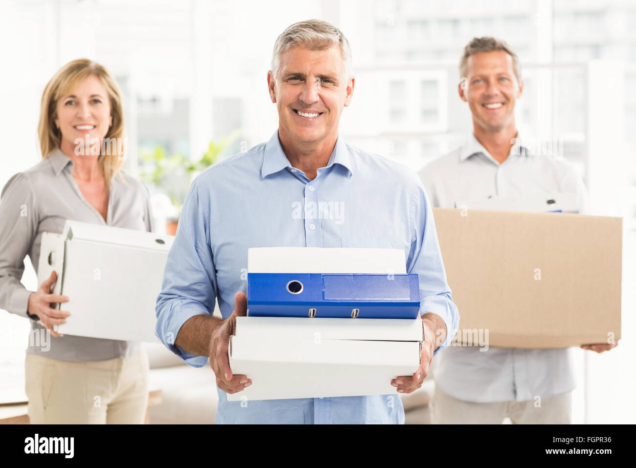 Casual business people carrying cartons Stock Photo - Alamy