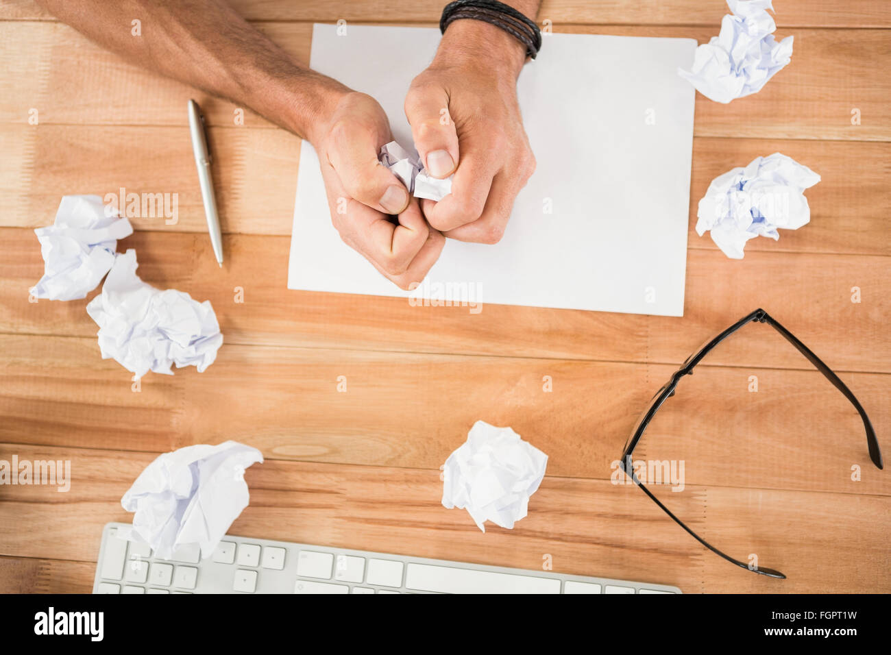 Hands crumpling paper on wooden desk Stock Photo - Alamy