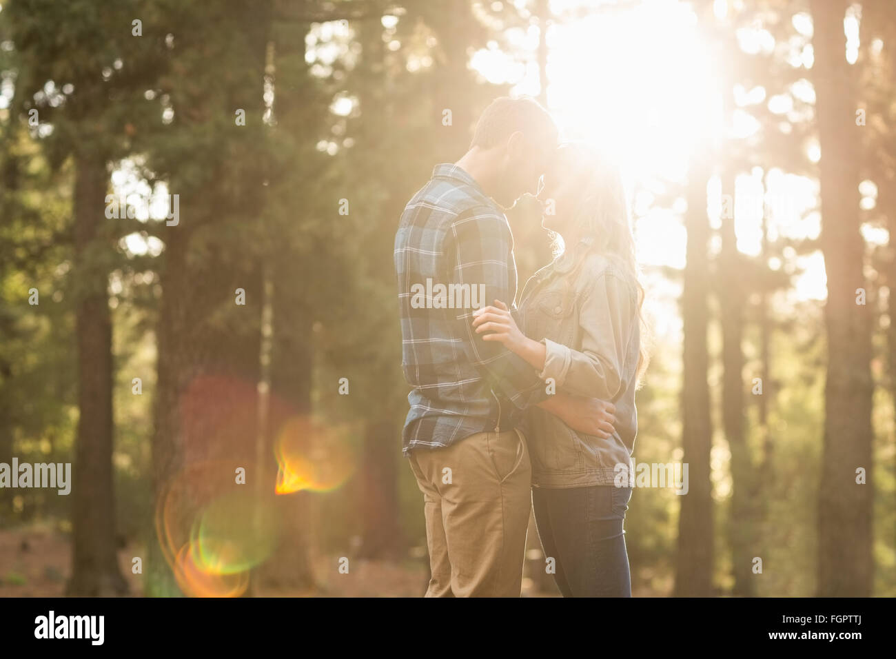 Happy couple embracing at sunset Stock Photo - Alamy