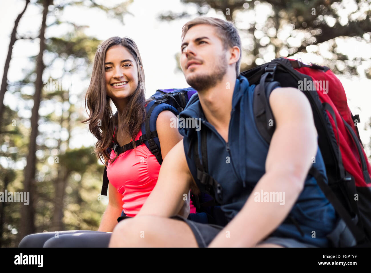 Young happy joggers sitting on rock and looking at camera Stock Photo ...