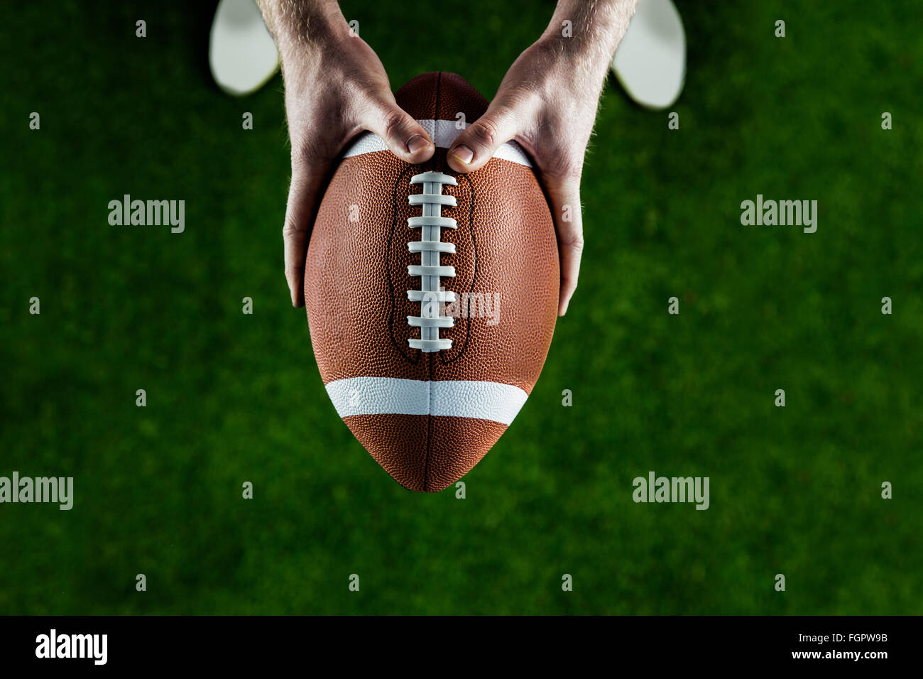 American football player holding up football Stock Photo - Alamy