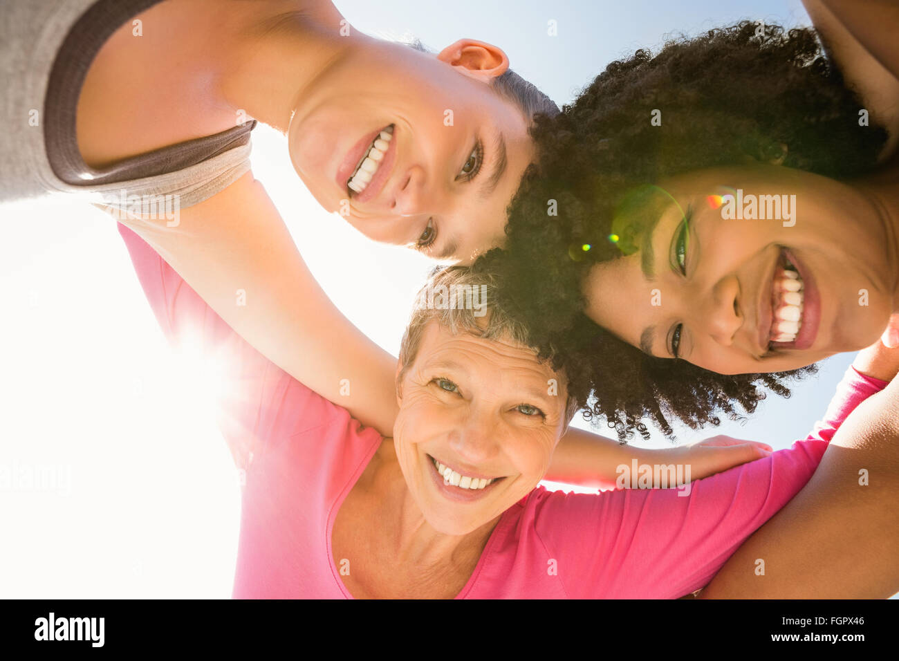 Sporty women with arms around smiling down to camera Stock Photo - Alamy