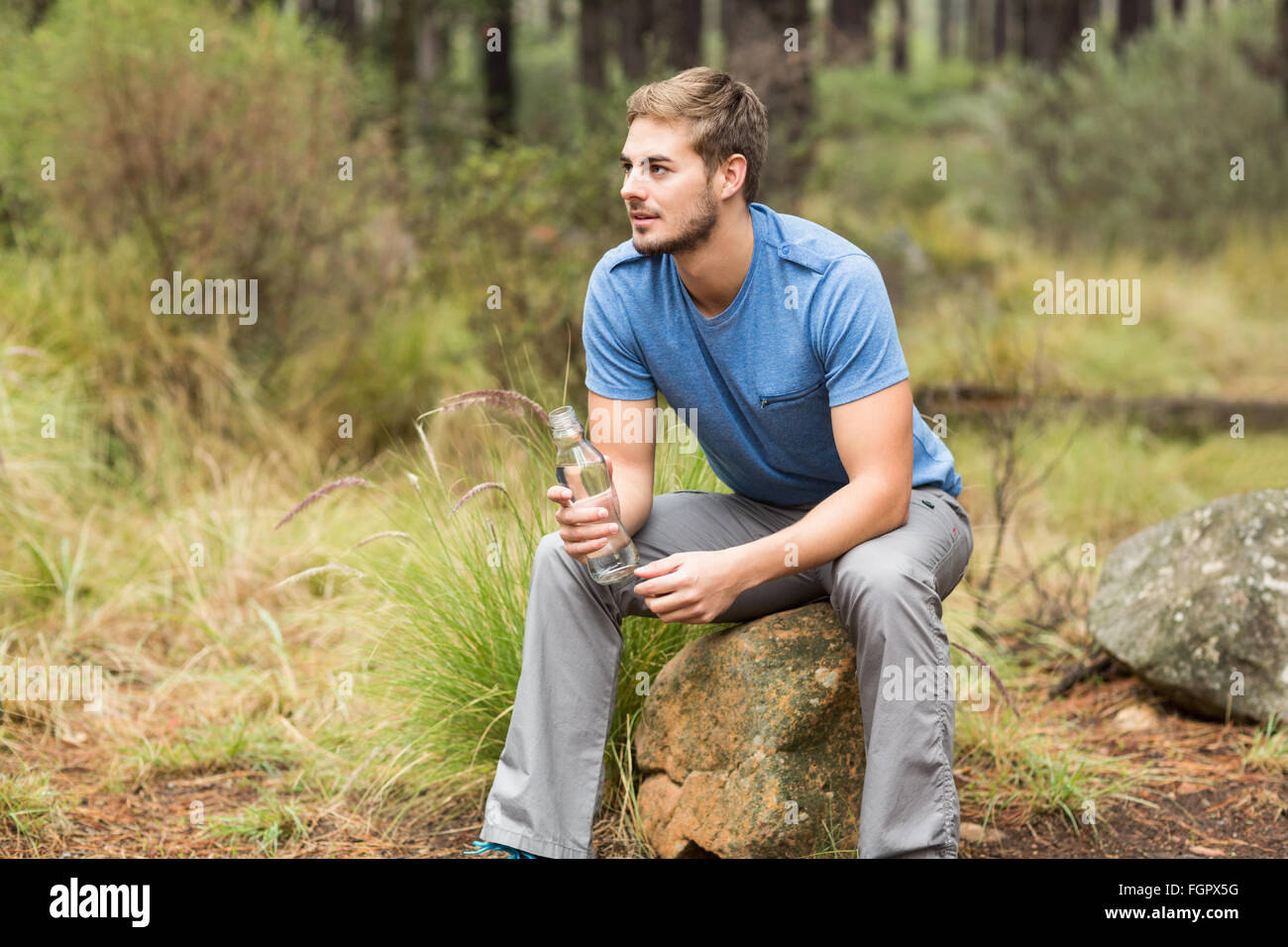 Handsome man sitting on a stone Stock Photo - Alamy