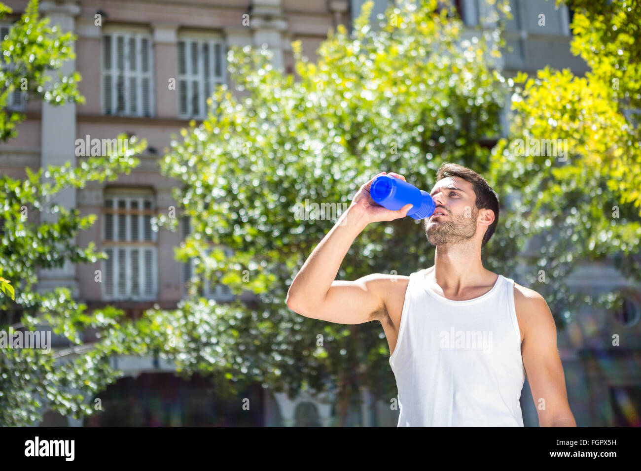 Handsome athlete drinking out of bottle Stock Photo - Alamy