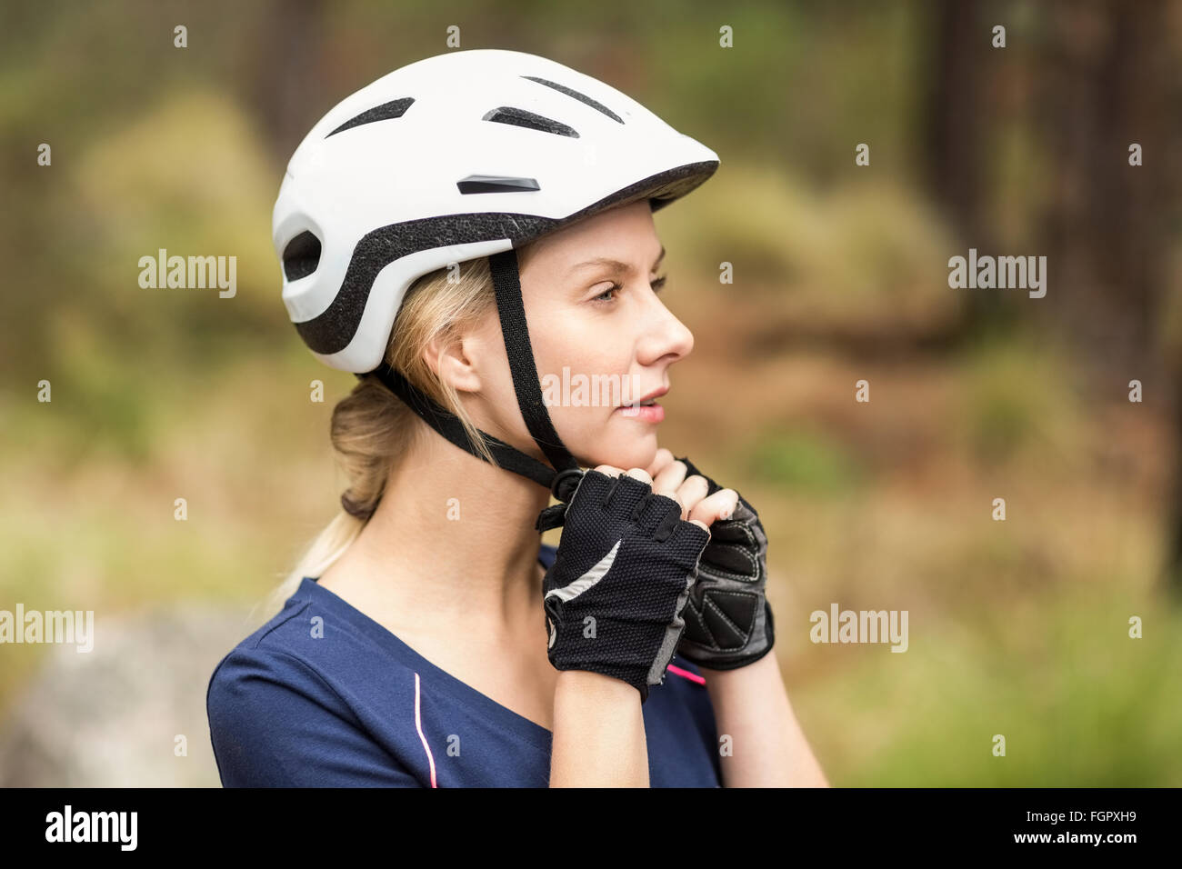 Young pretty happy biker taking off helmet Stock Photo - Alamy