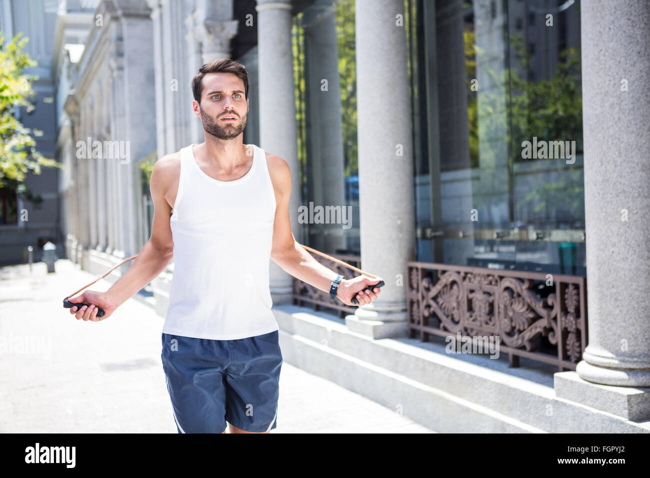 Handsome athlete skipping with jump rope Stock Photo - Alamy