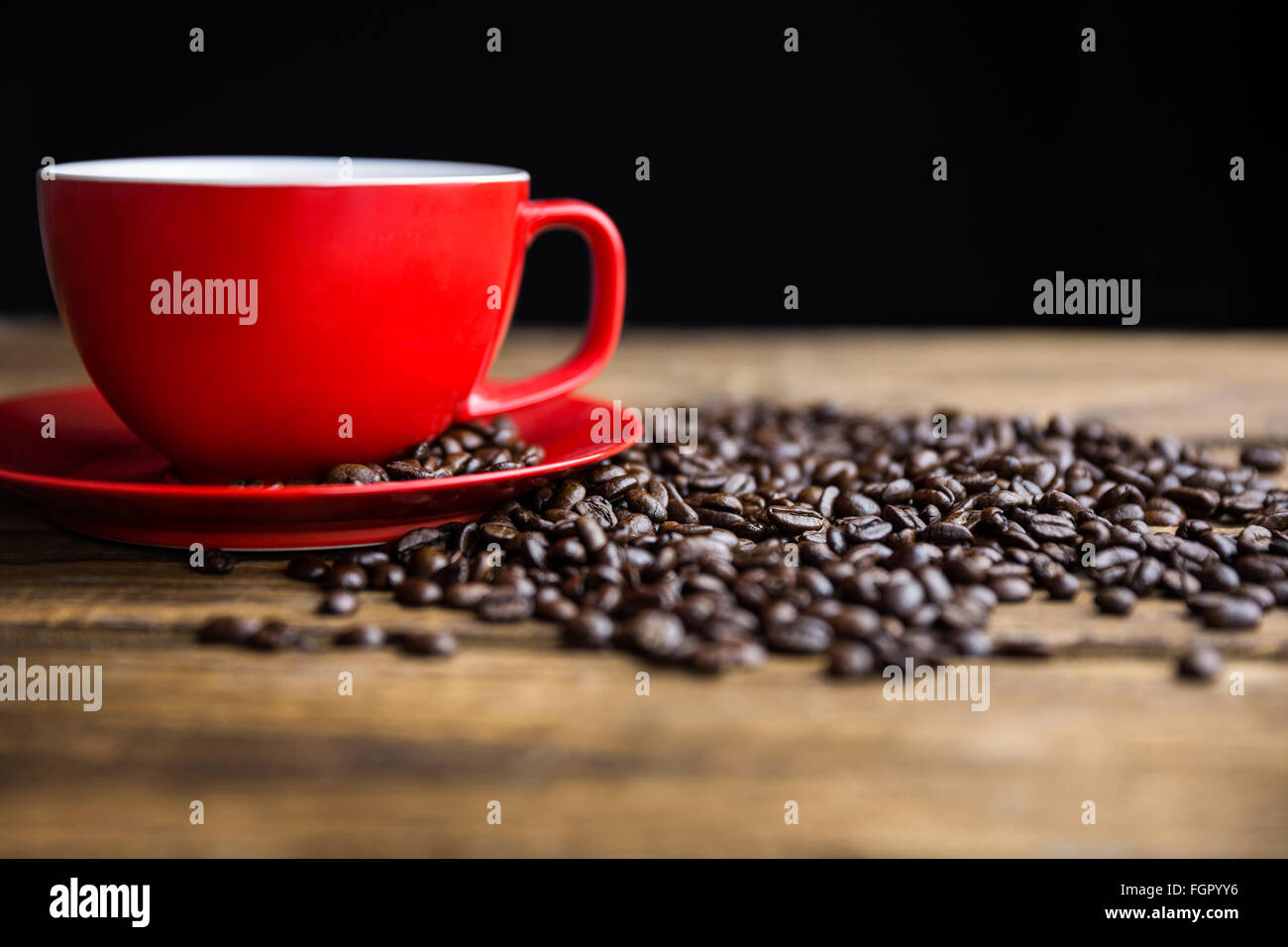 Coffee beans on a table with cup Stock Photo - Alamy