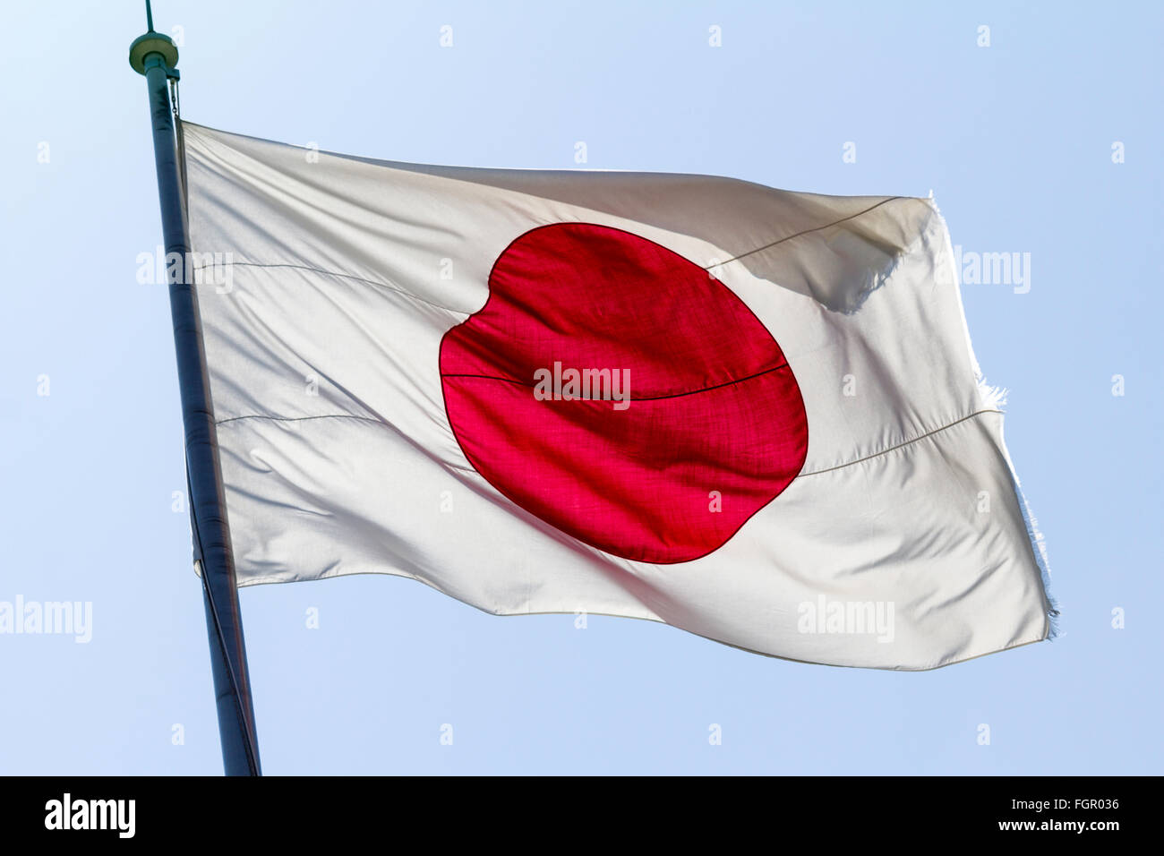Japanese rising sun flag, red ball on white background, fluttering in ...