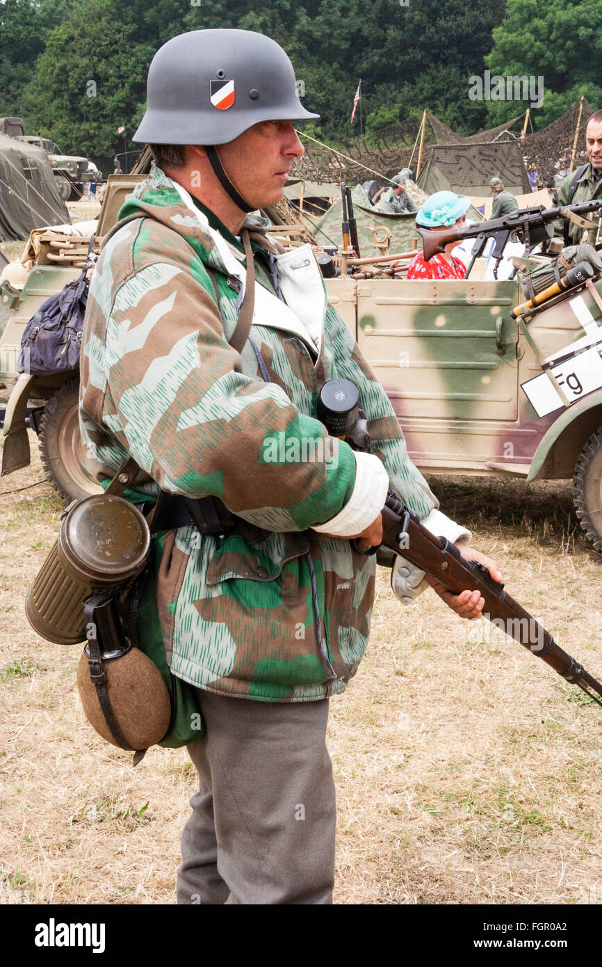 Second world war re-enactment. German sentry in camouflage smock, stick ...