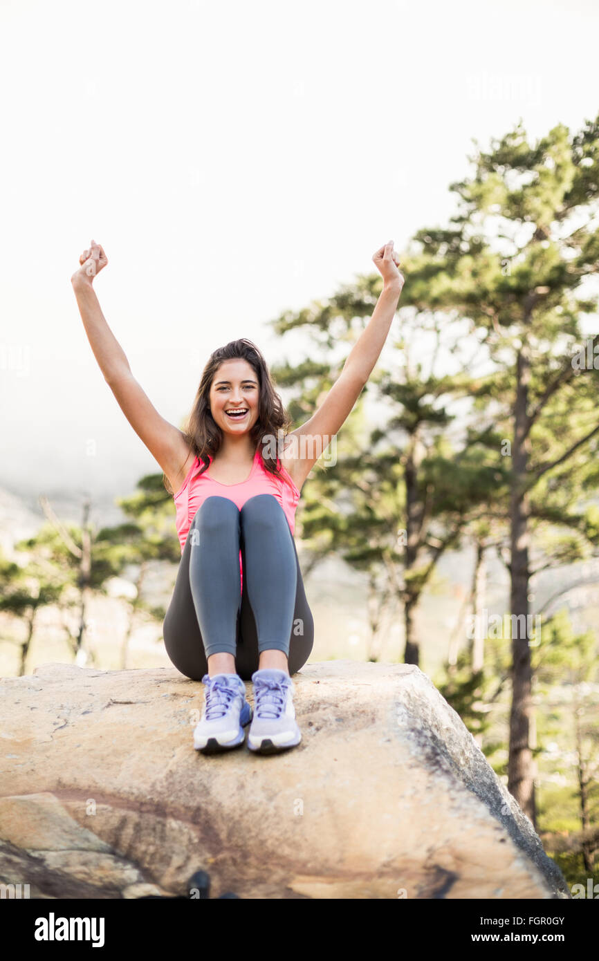 Young happy jogger sitting on rock cheering Stock Photo - Alamy