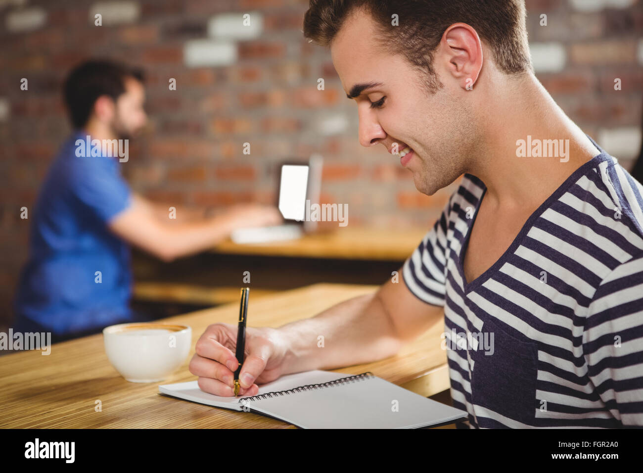Young man taking notes in his notebook Stock Photo - Alamy