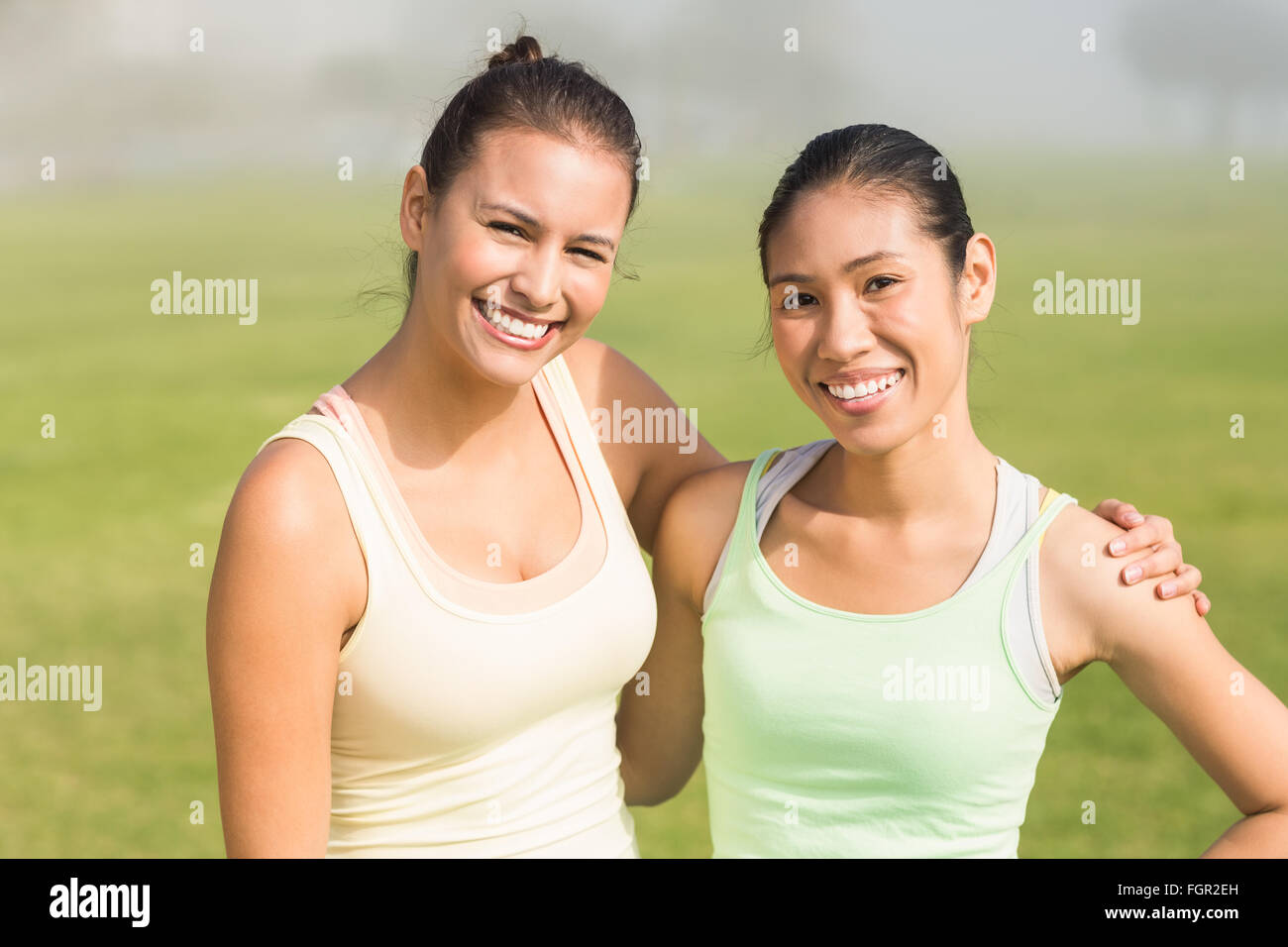 Smiling sporty women with arms around each other Stock Photo - Alamy