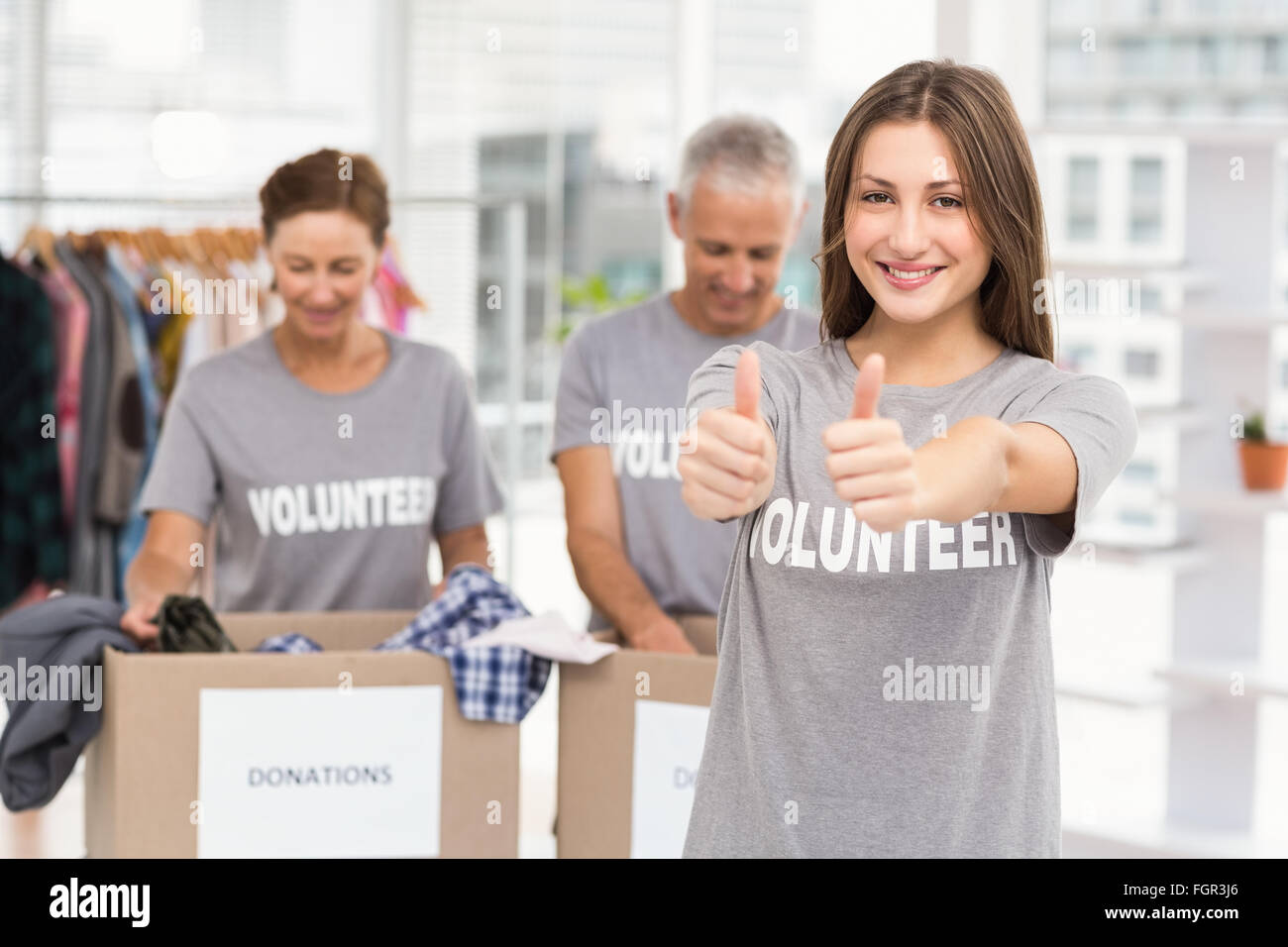 Smiling female volunteer doing thumbs up Stock Photo - Alamy