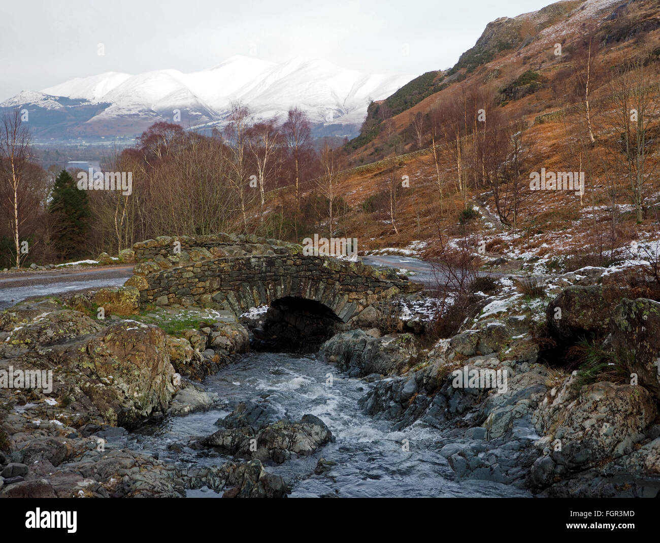 icy road over picturesque Ashness Bridge in Cumbria in Winter with snow ...