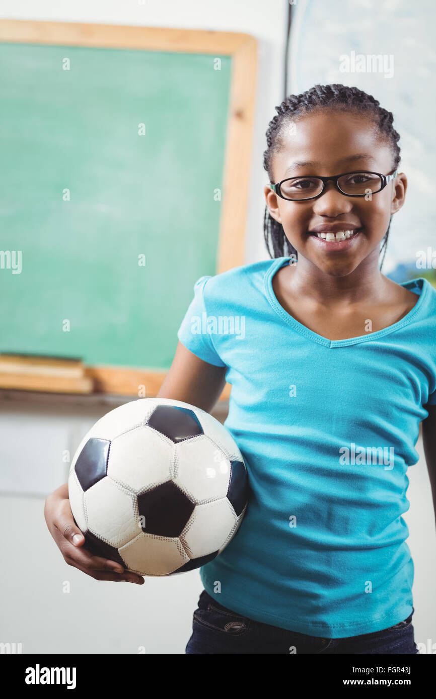 Smiling pupil holding football in a classroom Stock Photo - Alamy