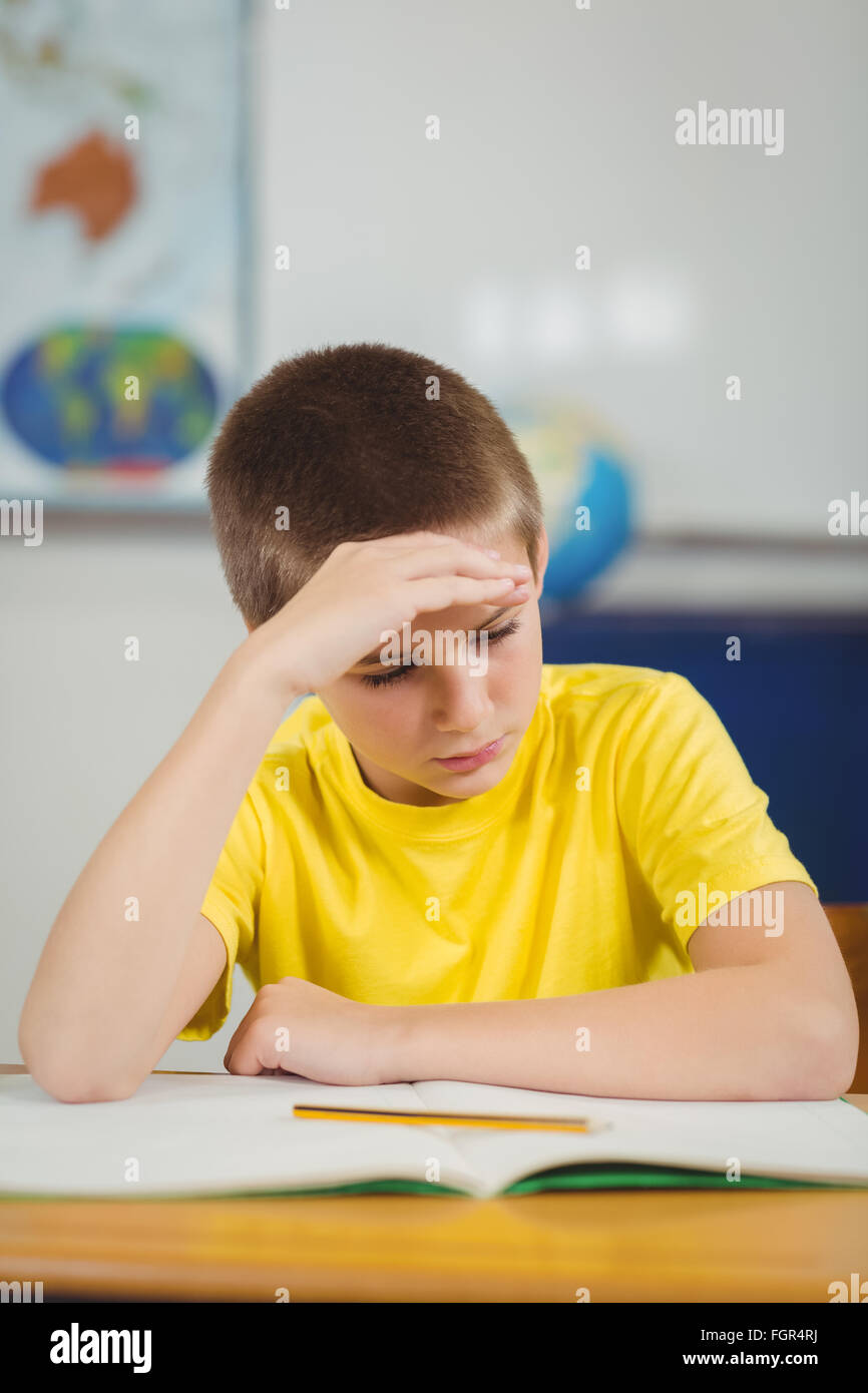Concentrated pupil working at his desk in a classroom Stock Photo - Alamy