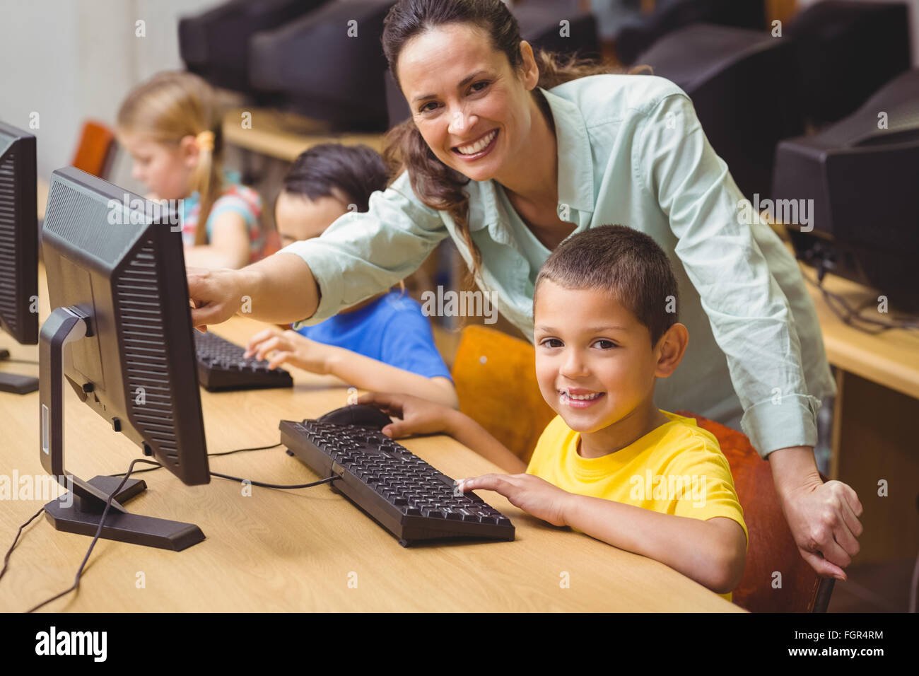Cute pupils in computer class with teacher Stock Photo - Alamy