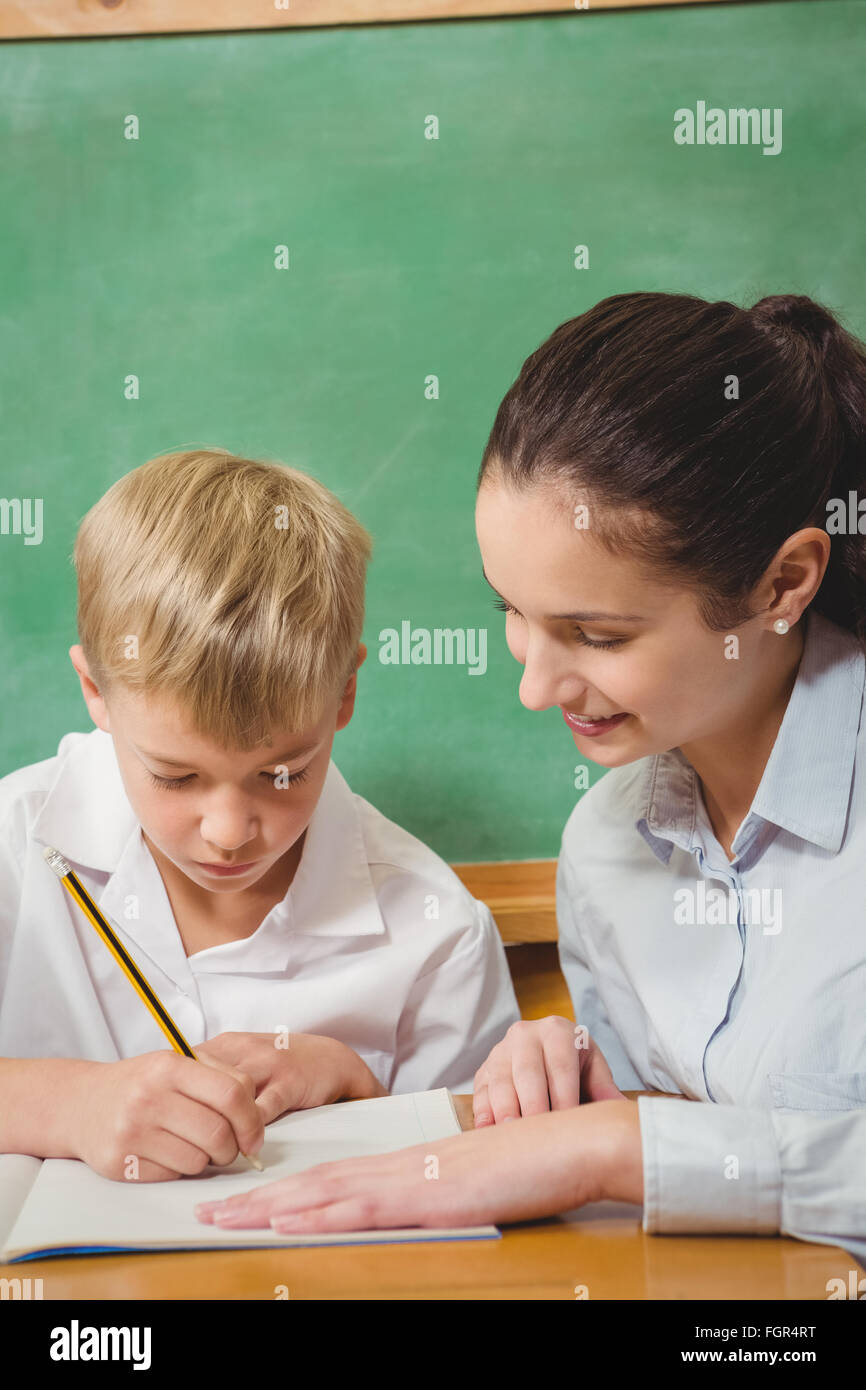Teacher helping a student in class Stock Photo - Alamy