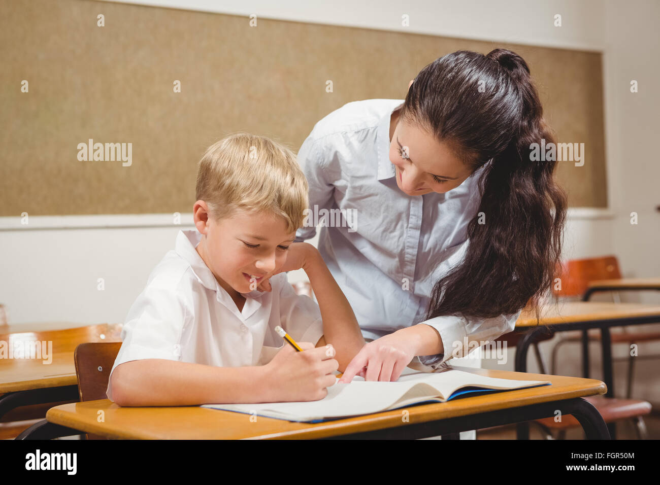 Teacher helping a student in class Stock Photo - Alamy