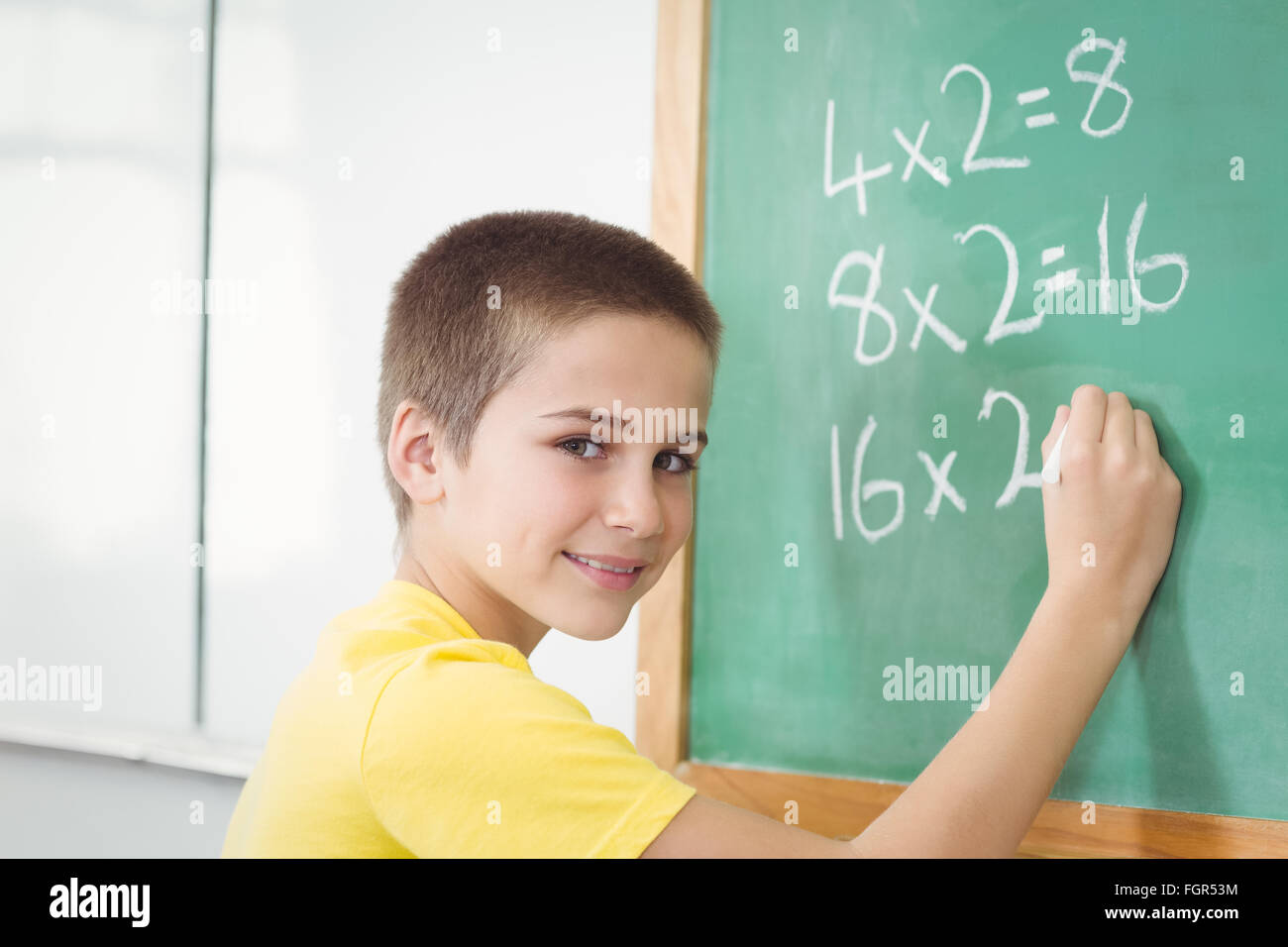Smiling pupil calculating on chalkboard in a classroom Stock Photo - Alamy
