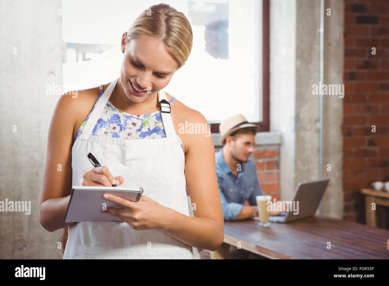 Smiling blonde waitress taking order in front of customer Stock Photo ...