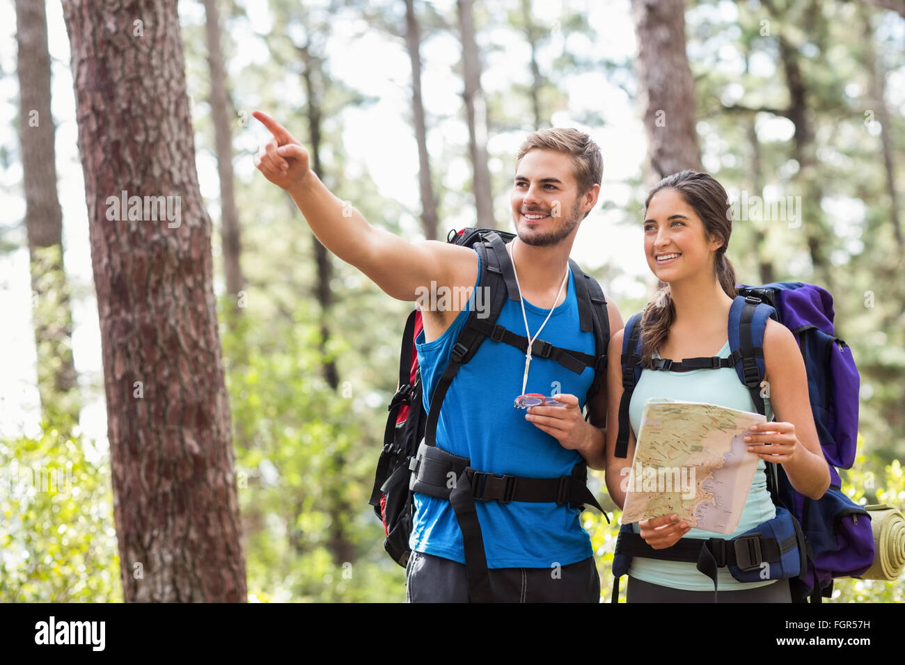 Happy hikers looking away holding map and compass Stock Photo - Alamy