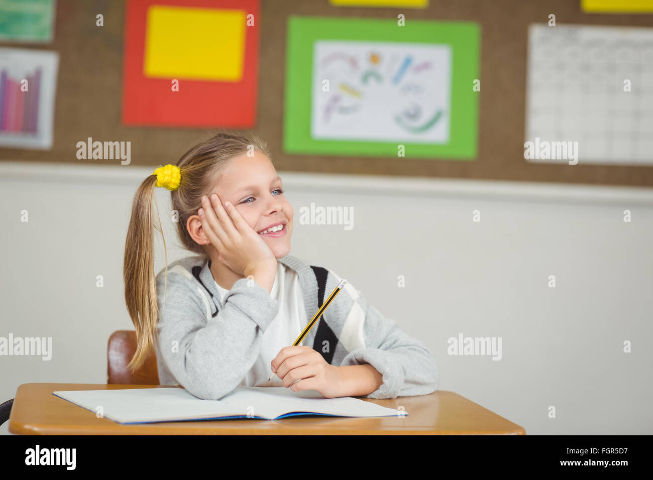 Smiling pupil daydreaming in a classroom Stock Photo - Alamy