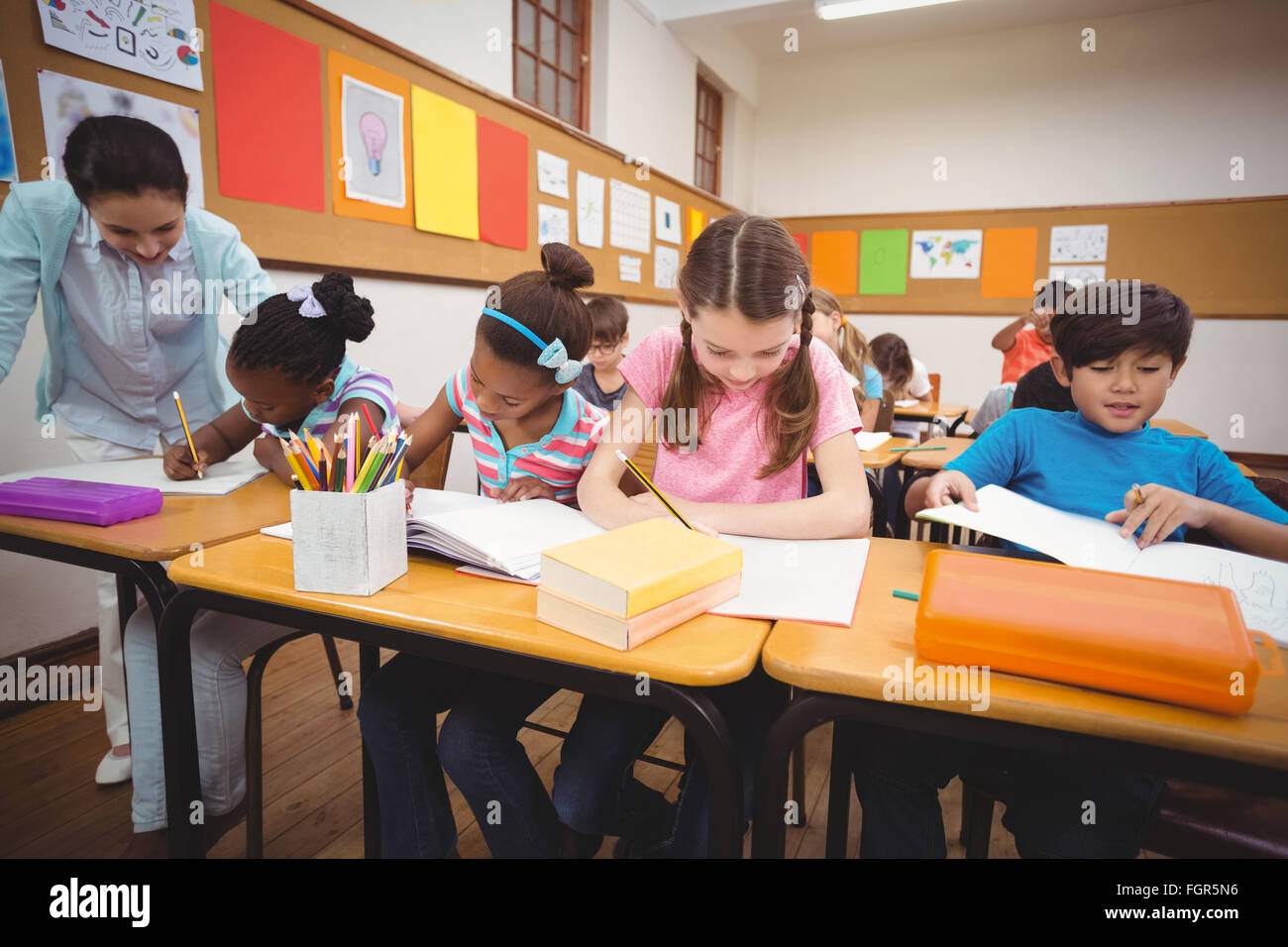 Pupils working at their desks in class Stock Photo - Alamy