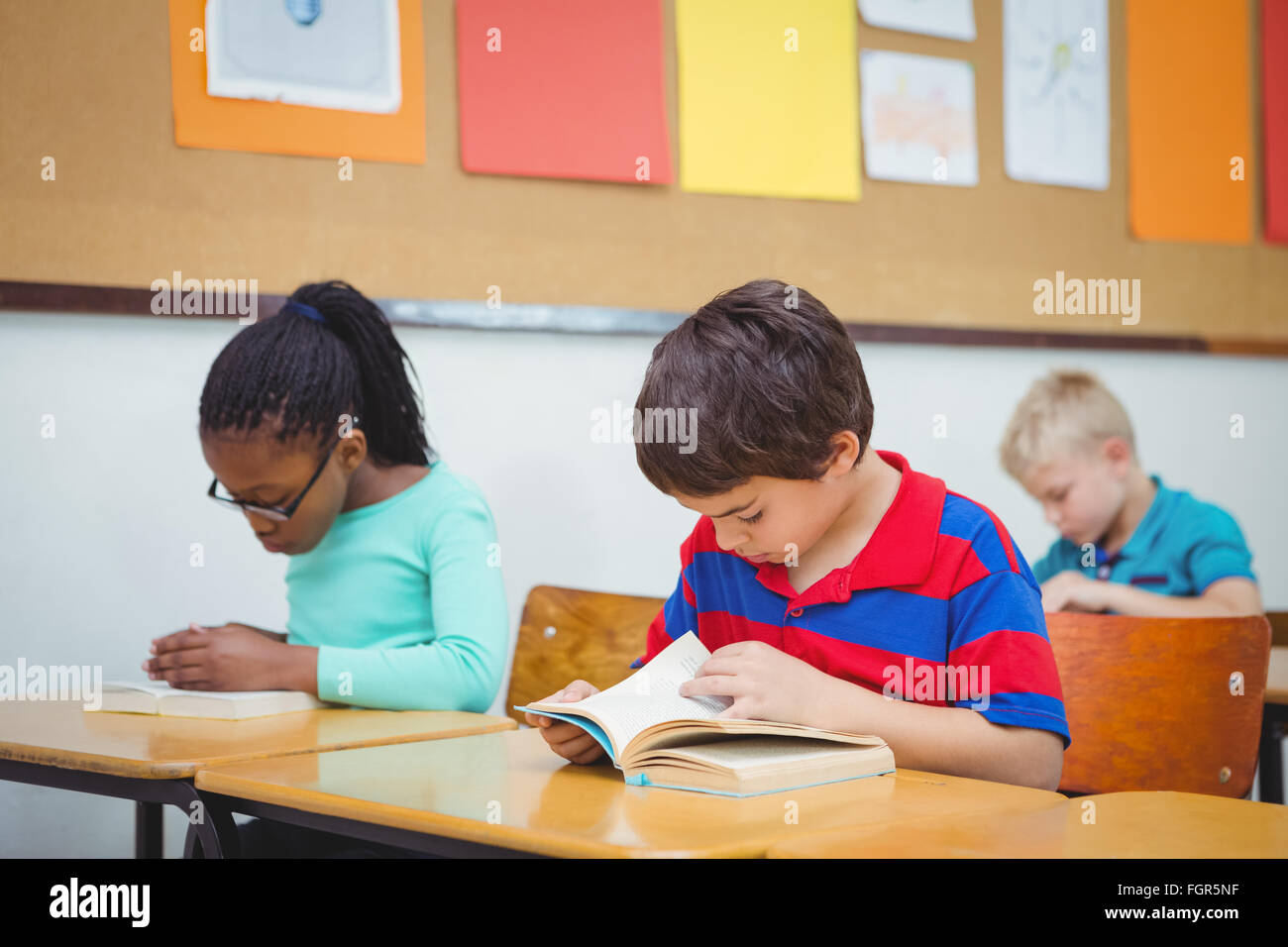 Pupil reading a school book Stock Photo - Alamy