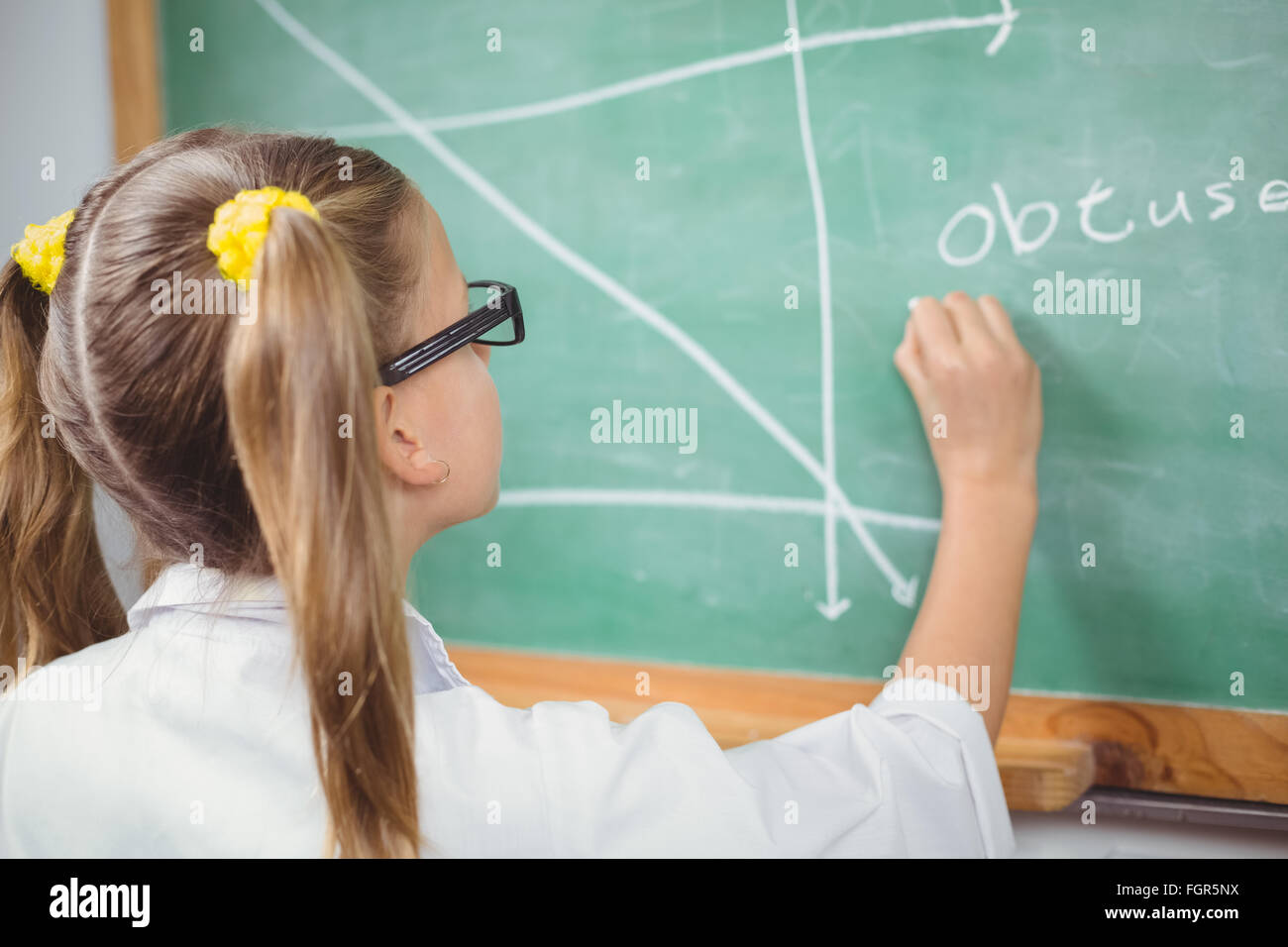 Pupil with lab coat writing on chalkboard in a classroom Stock Photo ...