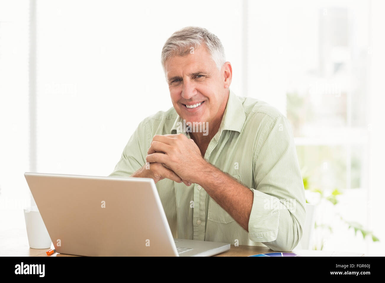 Smiling businessman working on a laptop Stock Photo - Alamy