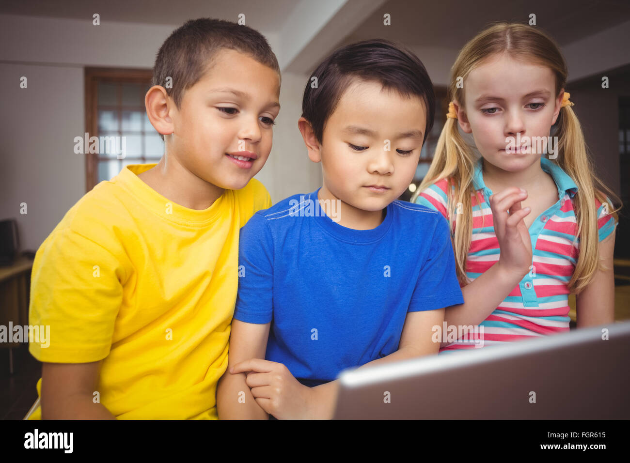 Cute pupils in computer class using laptop Stock Photo - Alamy