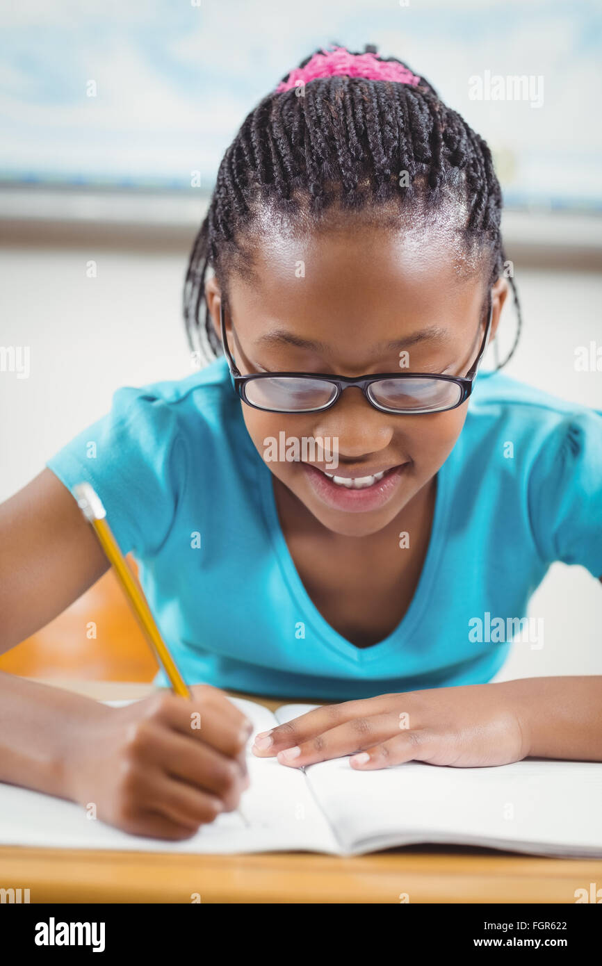 Smiling pupil working at her desk in a classroom Stock Photo - Alamy