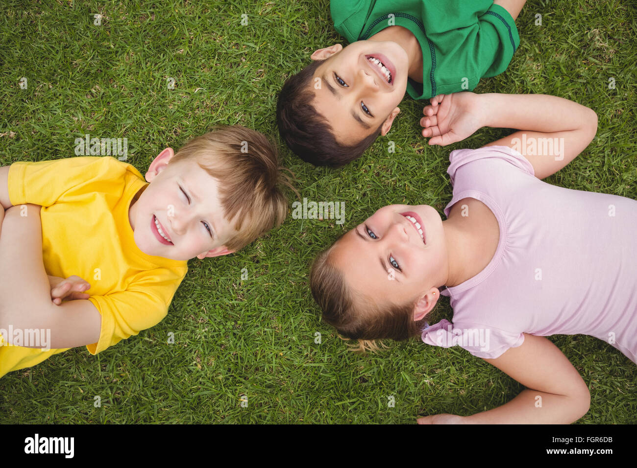 Smiling pupils lying on the ground Stock Photo - Alamy