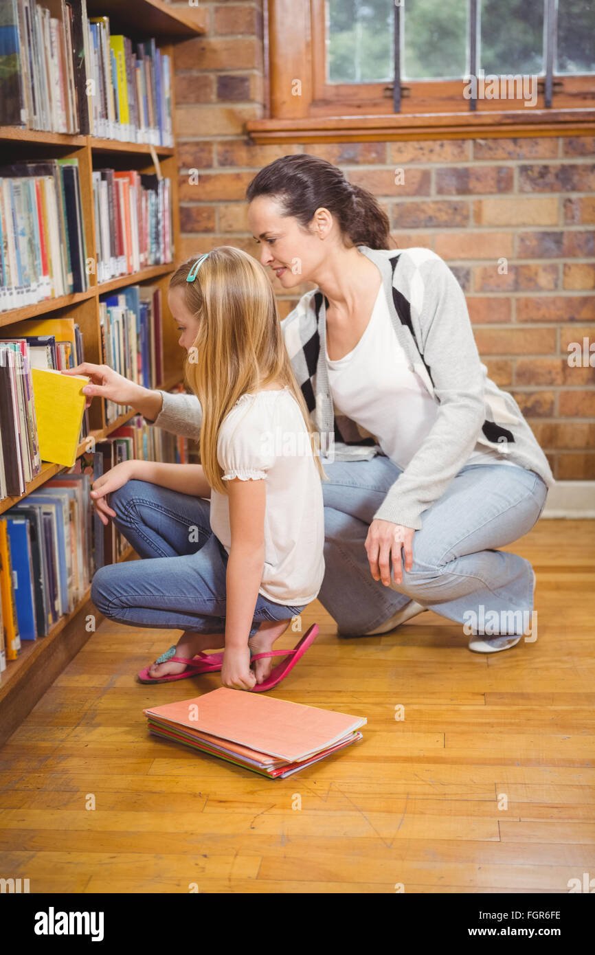 Teacher helping a student pick a book Stock Photo - Alamy
