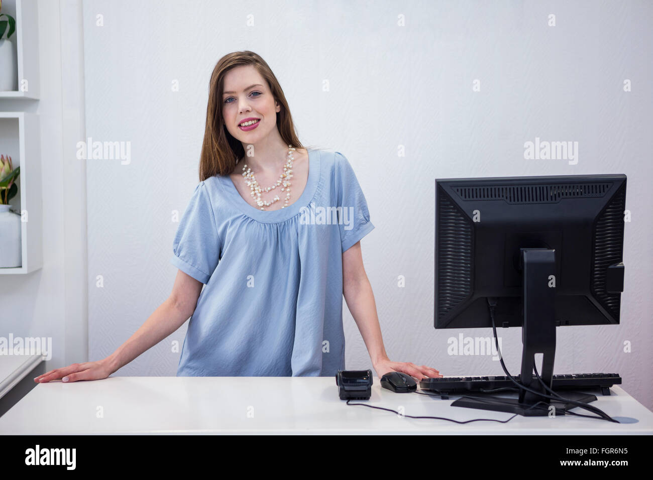 Shop worker standing by the till Stock Photo - Alamy