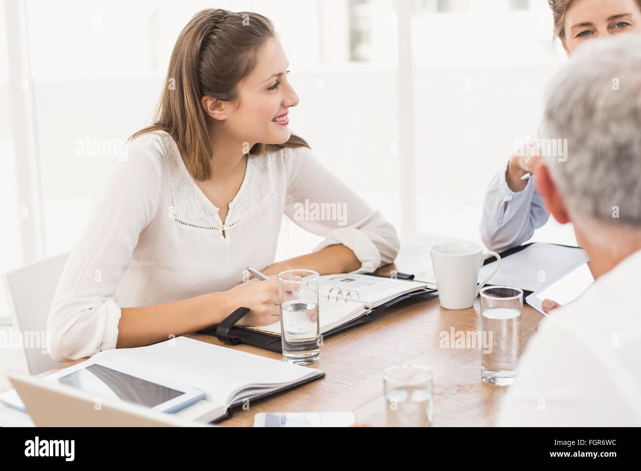 Smiling business people having a meeting Stock Photo - Alamy